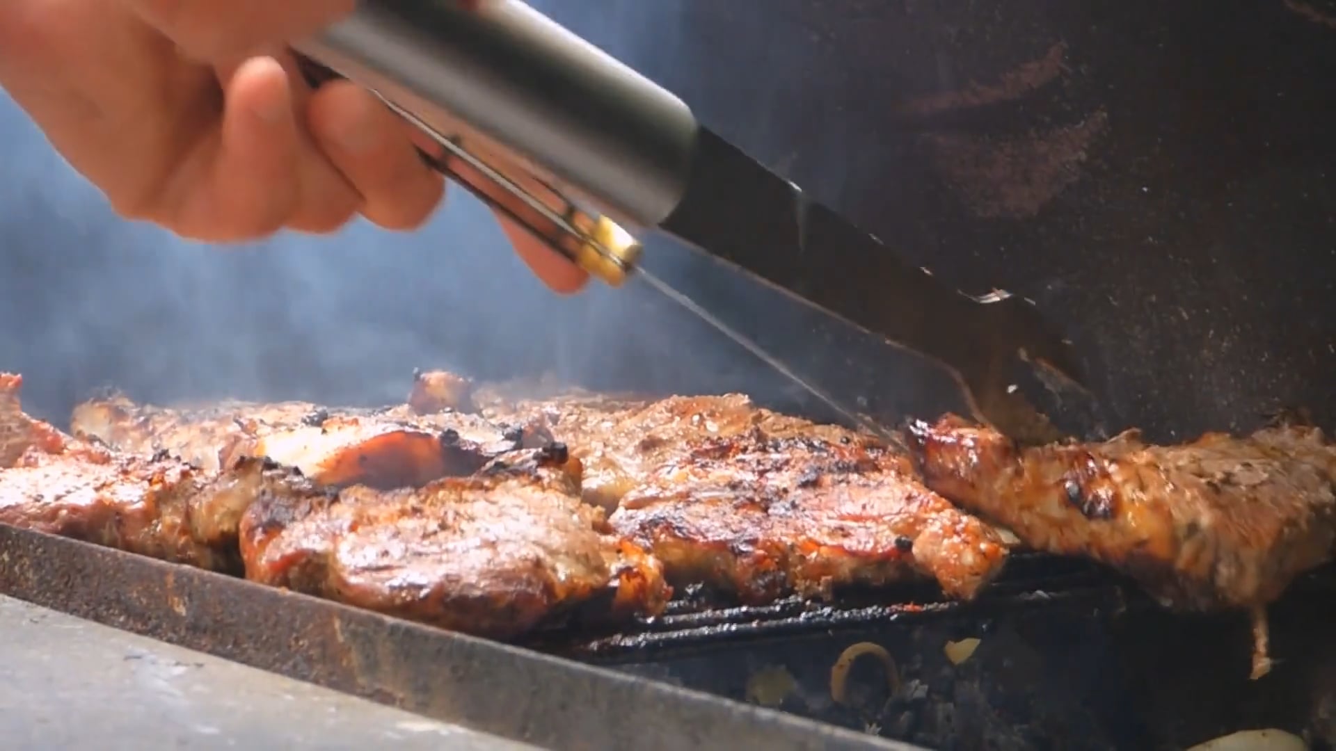 Man Flips Meat on Grill