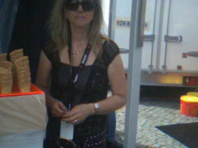 SEXY MATURE BLONDE HAIRED LADY WEARING GLASSES STANDING IN A LEATHER ...