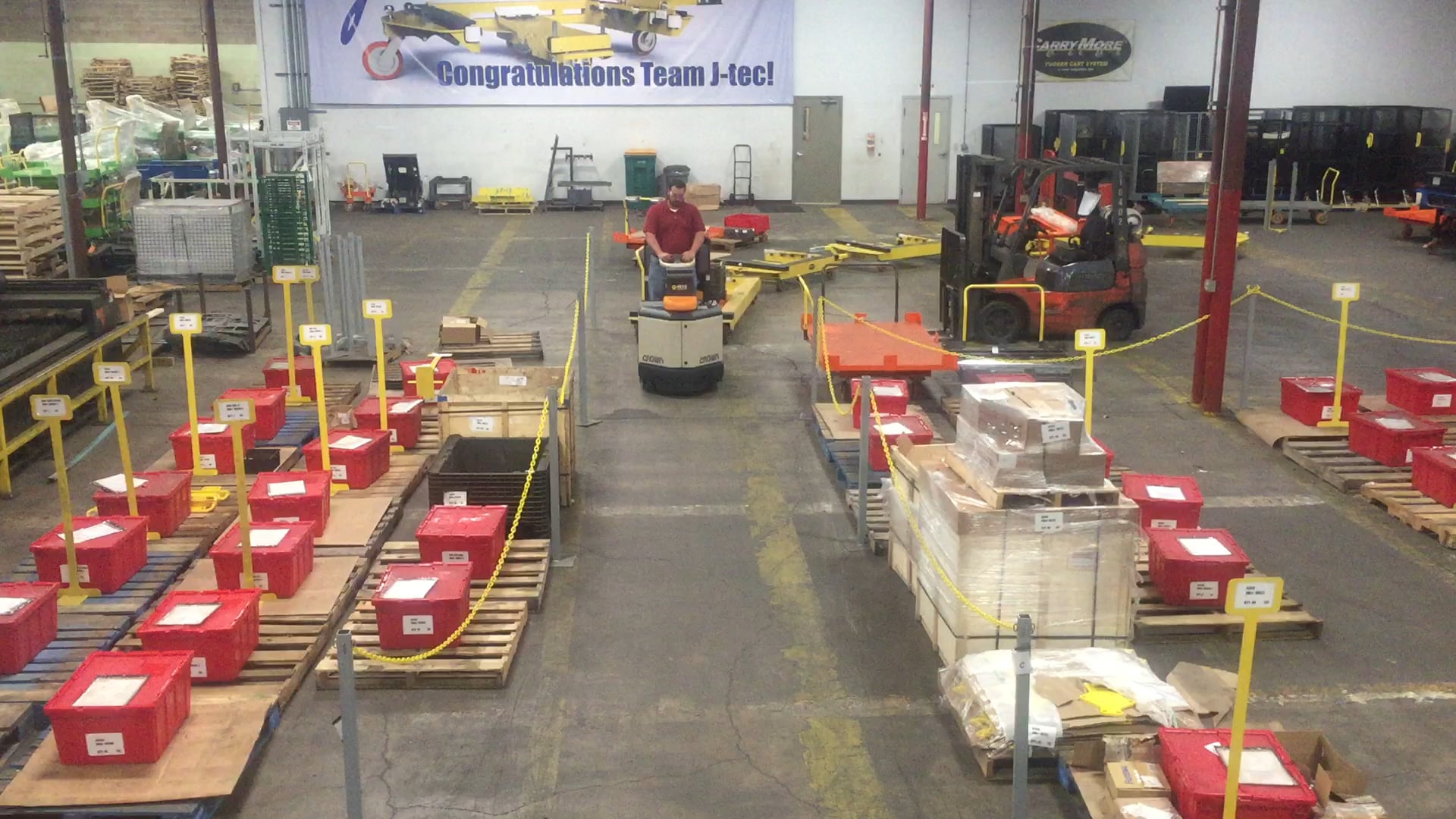 Crown Tugger pulling 5 standard CarryMore carts in a tight aisle on Vimeo