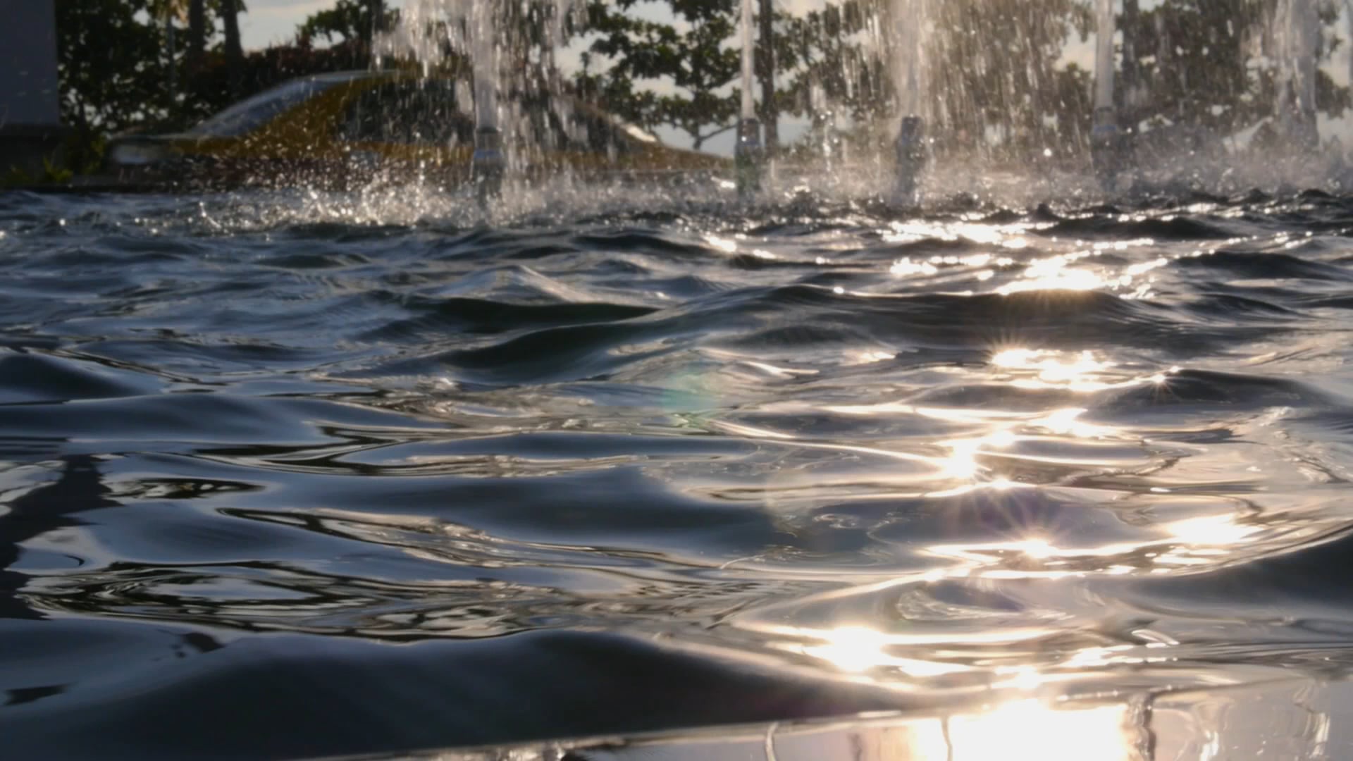 water-surface-with-sun-reflection-in-fountain-with-splashing-stream ...